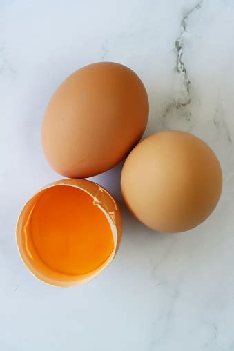 배치 치킨 계란의 이미지 대리석 효과 배경에 고립 된 노른자를 보여주는 깨진 스튜디오 샷 높은 보기 0명에 대한 스톡 사진 및