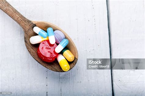 錠剤の完全木のスプーン薬局の背景白いテーブル白い背景の上の錠丸薬医学と健康カプセルのクローズ アップ薬の区分種類 いっぱいになるのストック