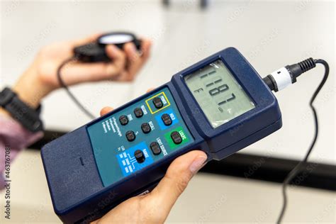 photo and art print hand holding digital handheld light lux meter