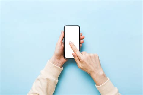 문자 메시지 또는 정보 콘텐츠에 대한 빈 복사 공간 화면이 있는 스마트폰을 들고 있는 여성의 상위 뷰입니다 여자 손 전화 흰색