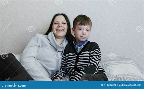 Watching Tv Lying On The Couch Mom And Son Watch Tv Together And Smile