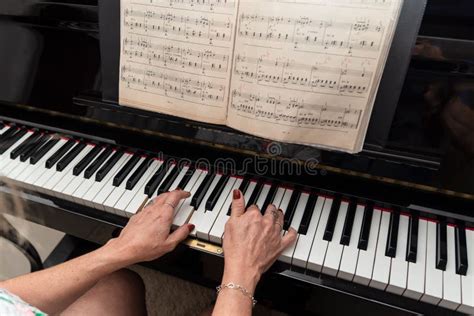 Female Musician Seated At A Grand Piano Playing A Melodic Tune With