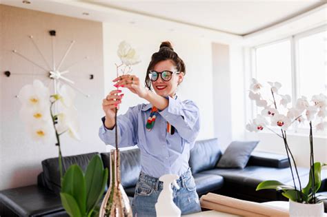 가정 식물과 꽃을 돌보는 주부 다채로운 난초 Phalaenopsis 가정 식물을 돌보는 여자 하얀 꽃을 들고 있는 정원사 가사