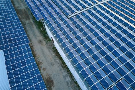 녹색 생태 전기를 생산하기 위해 산업 건물 지붕에 장착 된 푸른 태양광 태양 전지 판넬의 공중 보기 지속 가능한 에너지 개념의 생산 Performing Arts Event에