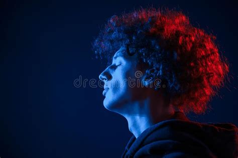 View From The Side Young Man With Curly Hair Is Indoors Illuminated By