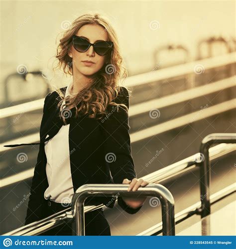 Young Fashion Blonde Business Woman In Sunglasses Leaning On Railing