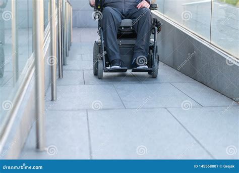 Homem Em Uma Cadeira De Rodas El Trica Usando Uma Rampa Imagem De Stock