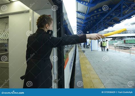 Female Train Conductor Signaling Departure Of The Passenger Train