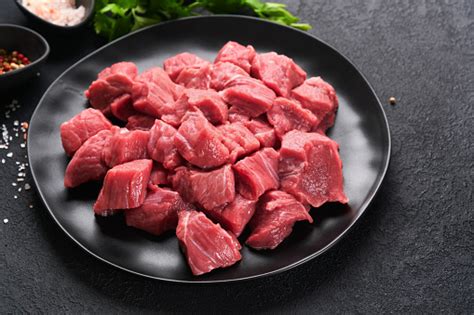 생 다진 쇠고기 고기 생 유기농 고기 쇠고기 또는 양고기 향신료 어두운 회색 콘크리트 배경에 검은 접시에 허브 굴라쉬 날것으로 조리되지 않은 고기 피가 든 고기 복사 공간이