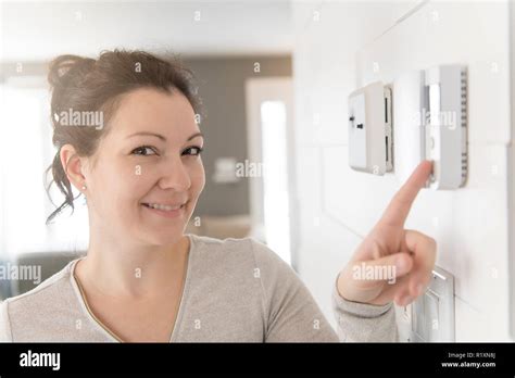 A Woman Set The Thermostat At House Stock Photo Alamy