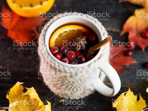 건조한 단풍 오렌지 계피 아니스와 함께 테이블에 전통적인 겨울과 가을 음료 Mulled 와인 또는 상그리아의 니트 머그잔 0명에