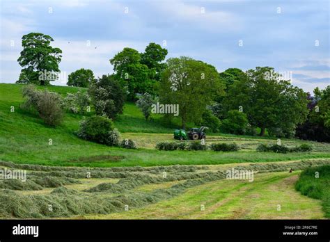 Haymaking Valmet Tractor Being Driven In Field Pulling Mchale F5400