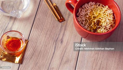 빨간 그릇에 인스턴트 국수 뜨거운 물 대나무 젓가락과 향신료는 테이블에 기름에 텍스트공간을 복사합니다 인기있는 아시아 요리 음식