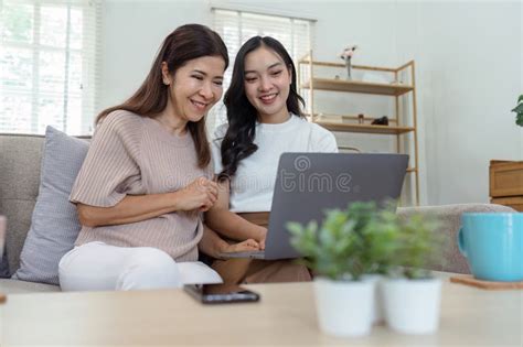Mother And Adult Daughter Sitting On The Sofa Together Mother And