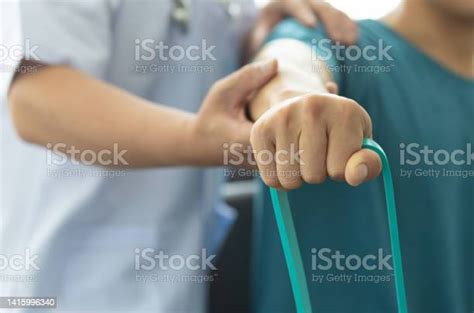 물리 치료사는 라텍스 치료 저항 밴드를 사용하여 운동으로 환자를 치료합니다 물리 치료 및 재활의 개념 물리치료에 대한 스톡 사진