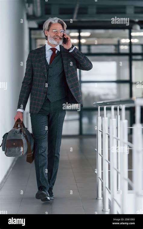 Senior Businessman In Suit And Tie With Gray Hair And Beard Walking
