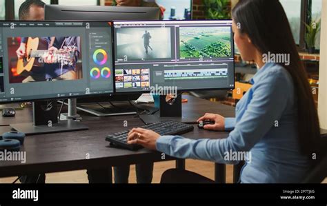 Asian Film Maker Working On Movie Footage Quality With Editing Software Using Multiple Monitors