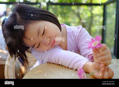 A Cute Shy Asian Girl Sitting By A Table At A Coffee Shop Relaxing And
