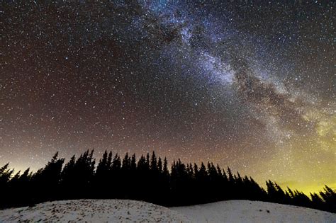 겨울 산 밤 풍경 파노라마입니다 어두운 가문비 나무 소나무 숲 위에 어두운 파란색 별이 빛나는 하늘에 은하수 밝은 별자리 일몰 후 수평선에 부드러운 빛 와이드 앵글 샷 0