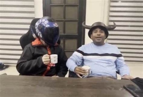 Two People Sitting At A Table With Masks On