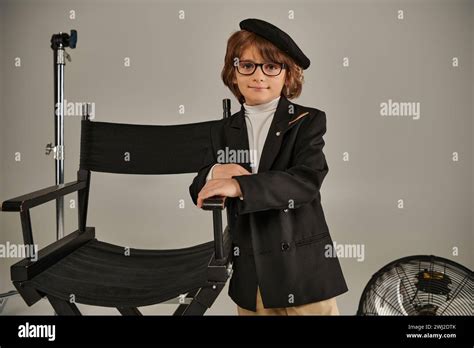 Cute Boy In Beret And Stylish Attire Stands Confidently Near Director