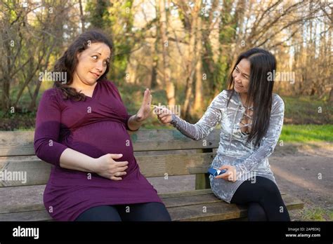 Pregnant Woman Sitting On The Bench In The Park And Rejecting The