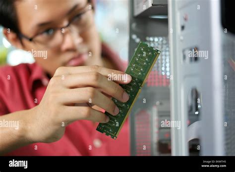 Young Asian Shop Owner Working In Computer Store Repairing Computer And Adding Ram To Pc Focus