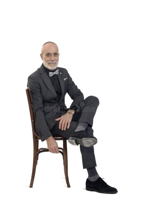Side View Of A Middle Aged Man Sitting On Chair Looking At Camera Stock