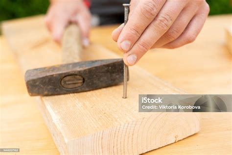 Dari Dekat Pria Yang Memalu Paku Ke Papan Kayu Menggunakan Palu Dan