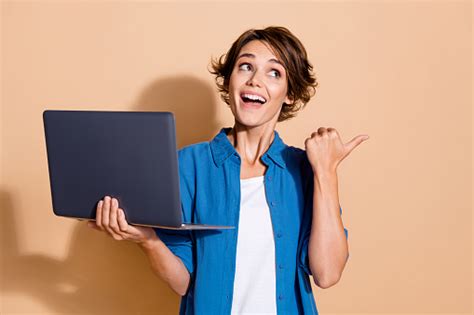 비즈니스 운영에서 젊고 쾌활한 데이터 분석의 사진 여자는 베이지 색 배경에 고립 된 노트북을 사용하여 손가락 차트를 가리킨다 25 29세에 대한 스톡 사진 및 기타 이미지