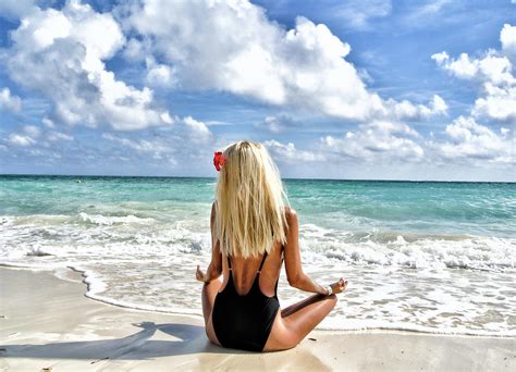 Woman Wearing Black Monokini Meditating On In Front Of Sea Under Blue