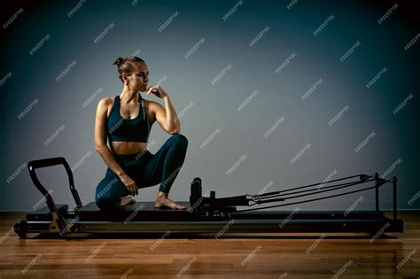 Premium Photo Young Girl Doing Pilates Exercises With A Reformer Bed