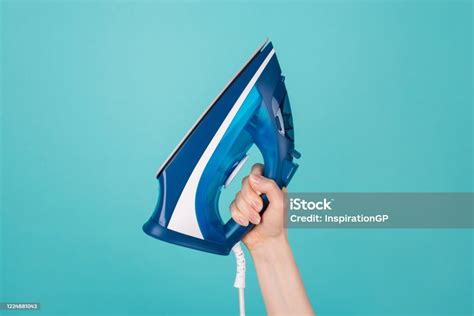 하우스 키핑 컨셉 청록색 배경에 고립 된 전기 철을 들고있는 여성의 자른 사진 다리미에 대한 스톡 사진 및 기타 이미지