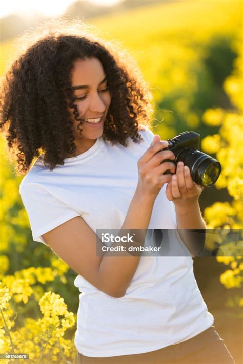 아름 다운 행복 한 혼합된 인종 아프리카계 미국인 여자 십 대 여성 젊은 여 자가 카메라와 함께 사진을 찍는 햇빛에 야외에서 웃 고 꽃 식물에 대한 스톡 사진 및 기타