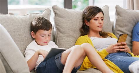 디지털 태블릿 스마트 폰 및 가족 가정의 소파에있는 어린이 독서 전자 책 온라인 소셜 미디어 모바일 앱 또는 웹 게임 인터넷 와이파이 및 거실의 소파에 기술을 가진 아이들