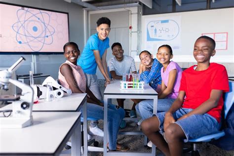In School Science Lab Group Of Students Smiling And Sitting Around