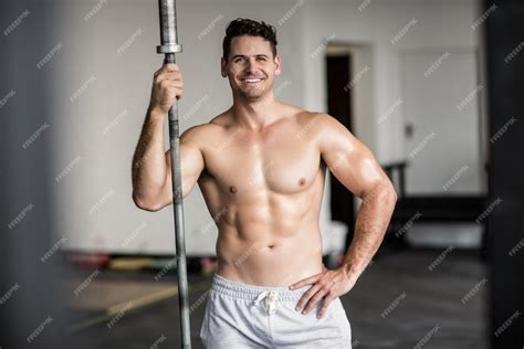 Premium Photo Muscular Smiling Man Holding Barbell