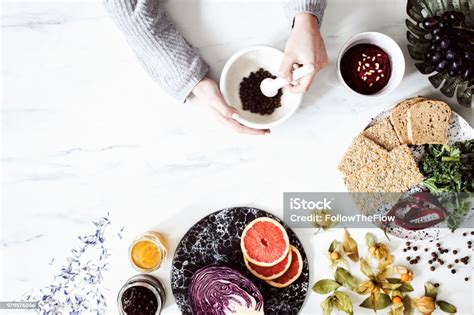 여자는 부엌에 그녀의 건강 한 음식 선택 과일 야채 슈퍼 식품 씨앗 대리석 백그라운드 복사 공간 건강한 생활방식에 대한 스톡