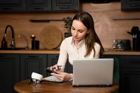 Premium Photo A Young Brunette Woman Makes Notes Makes Calculations