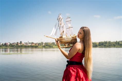 Woman In Red Dress Holding Boat Model On The Beach Stock Image Image