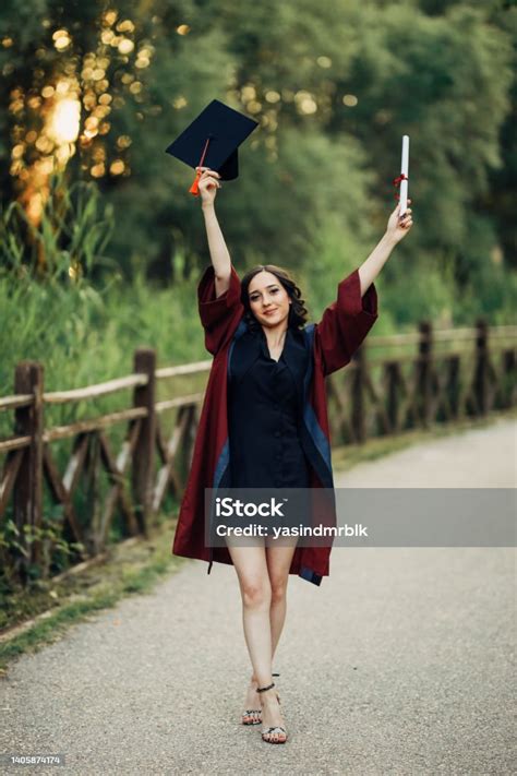 일몰에 졸업 가운을 입고 모자와 졸업장을 손에 들고 젊은 여성의 재미있는 초상화 졸업 사진 20 24세에 대한 스톡 사진 및 기타 이미지 Istock