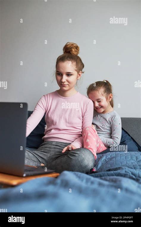 Teenage Girl And Her Younger Sister Playing Learning On Laptop Spending