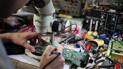 Man Looks At Motherboard Through Microscope And Stock Video Video Of Mobile Equipment 322720377