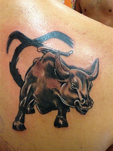 A Bull Tattoo On The Back Of A Mans Upper Arm With An Arrow In It