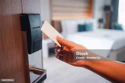 침실 배경이 있는 호텔 방에 액세스하기 위해 키 카드를 들고 있는 손 보안 및 개인 정보 보호 개념입니다 객실 열쇠에 대한 스톡