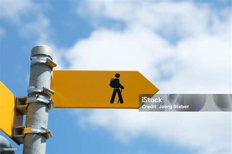 오른쪽을 가리키는 금속 돛대에 있는 스위스 하이킹 트레일의 노란색 표지판 카미노 데 산티아고에 대한 스톡 사진 및 기타 이미지