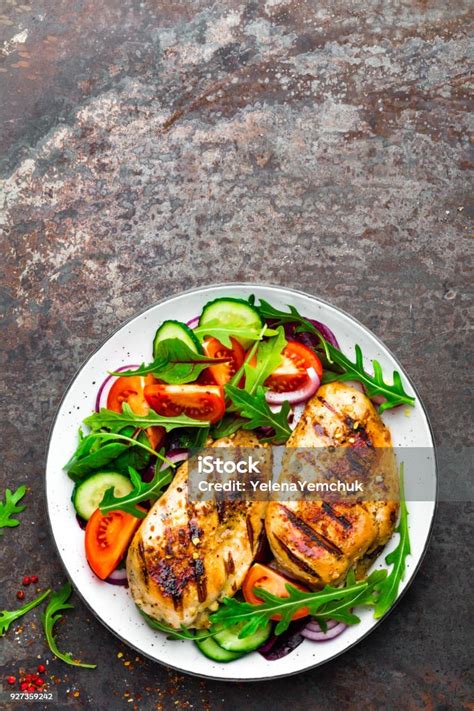 구운된 닭 가슴살입니다 후 라 이드 치킨 필렛 고 토마토 오이 및 Arugula 잎의 신선한 야채 샐러드 치킨 샐러드와 고기입니다 건강 한 음식입니다 플랫이 하다 최고의 볼