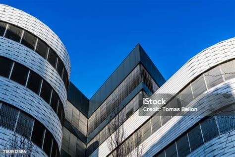 Modern Architectural Design With Curved And Angular Facades Against A