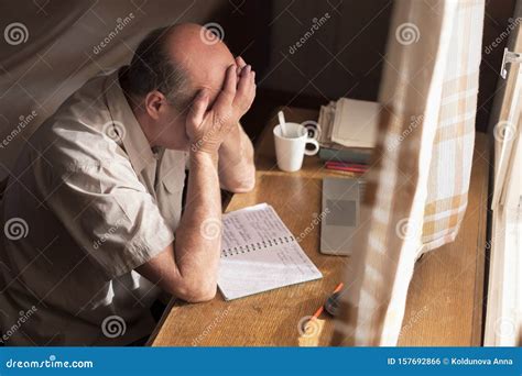 Un Anciano Cansado Que Se Toma La Mano Tras Trabajar En Una Laptop Foto