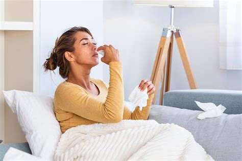 여자는 독감이 있고 그녀는 자신을 돕기 위하여 비강 스프레이를 사용하고 있습니다 비강 스프레이를 사용하는 여성 감기에 도움이 되는 비강 스프레이 비염 여성이 코를 떨어